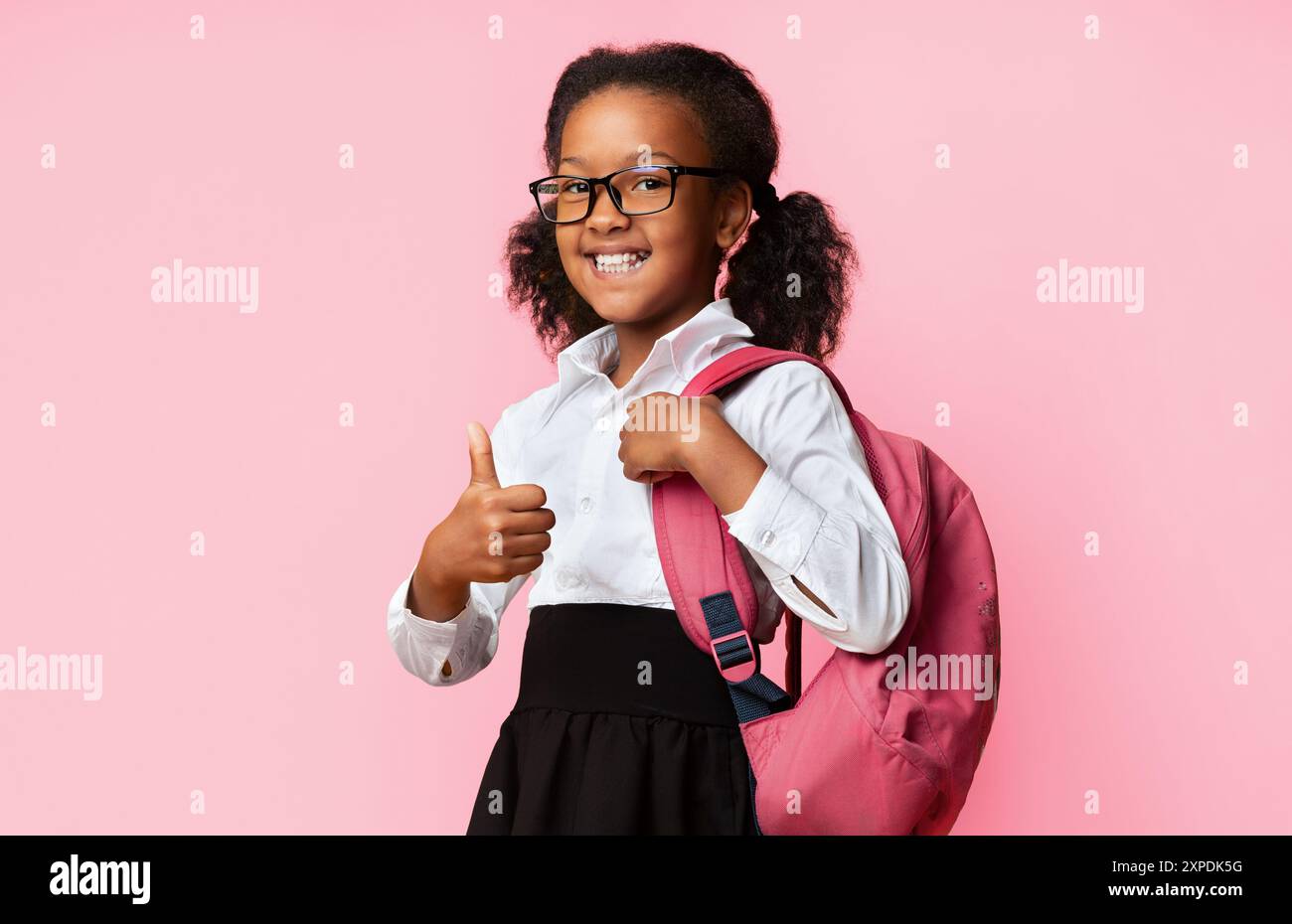 African American School Girl Gesturing Thumbs-Up Over Yellow Studio ...