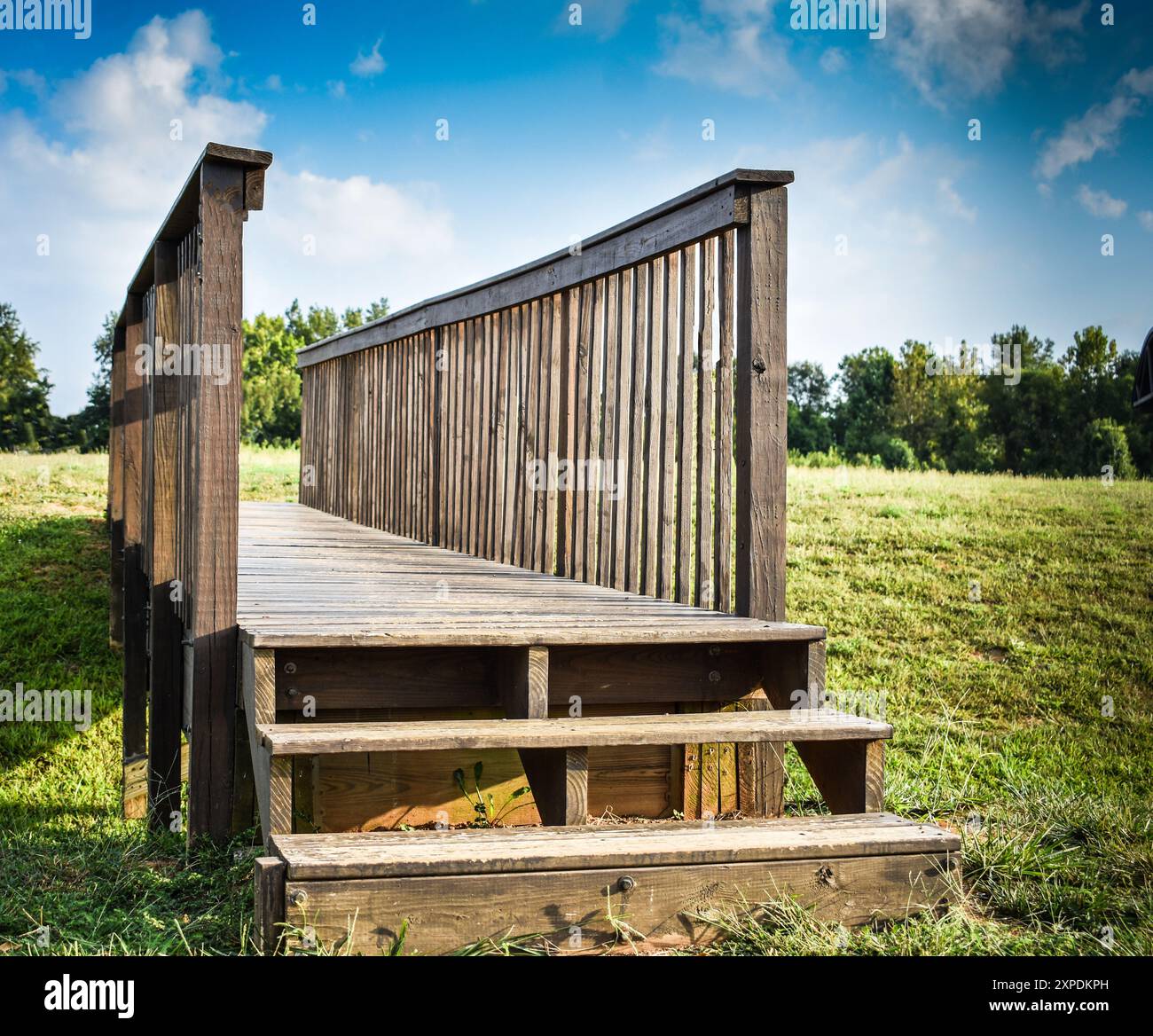Wooden footbridge over shallow grass-lined swail Stock Photo - Alamy