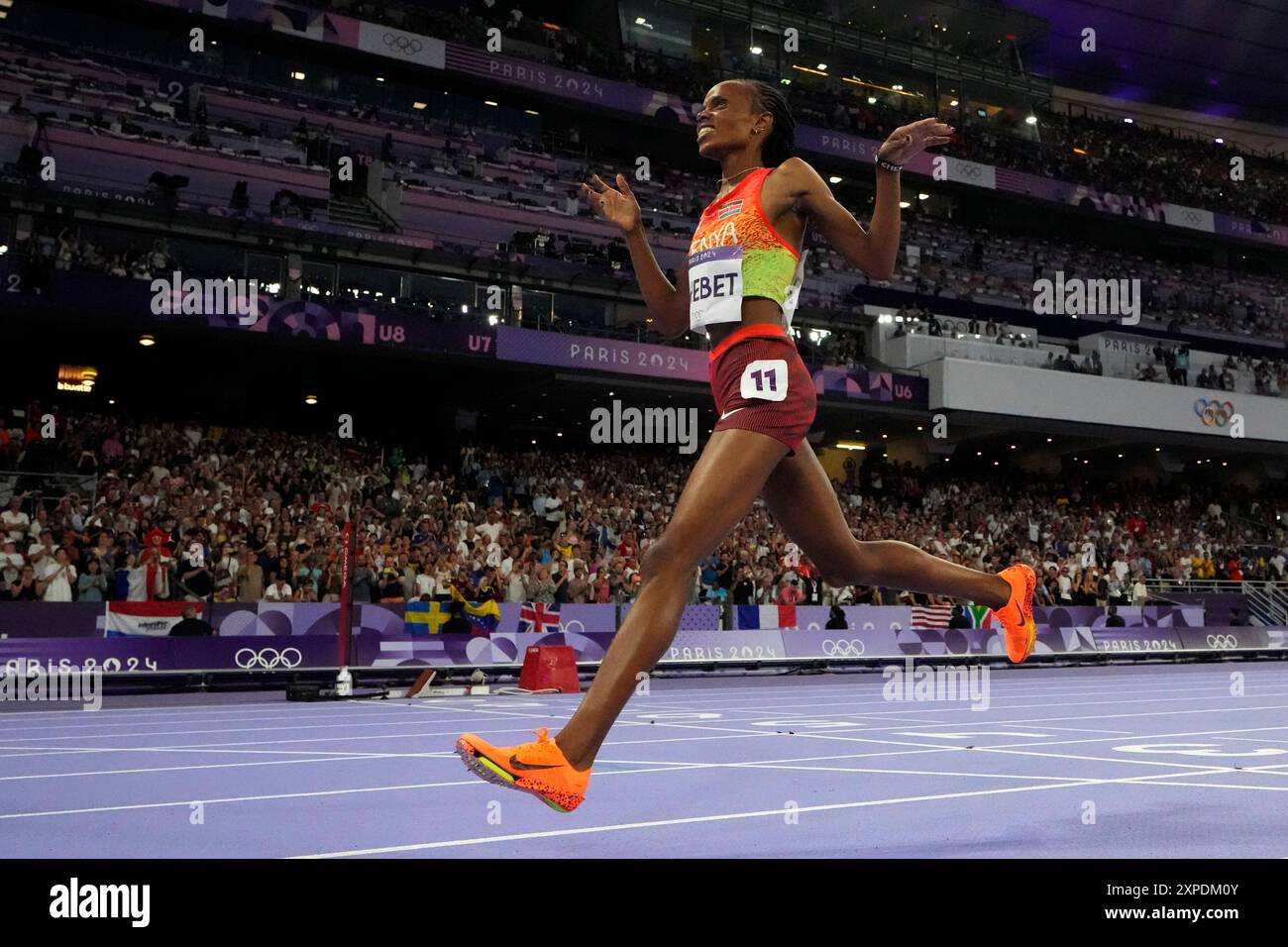 Beatrice Chebet, of Kenya, celebrates as she crosses the finish line to ...