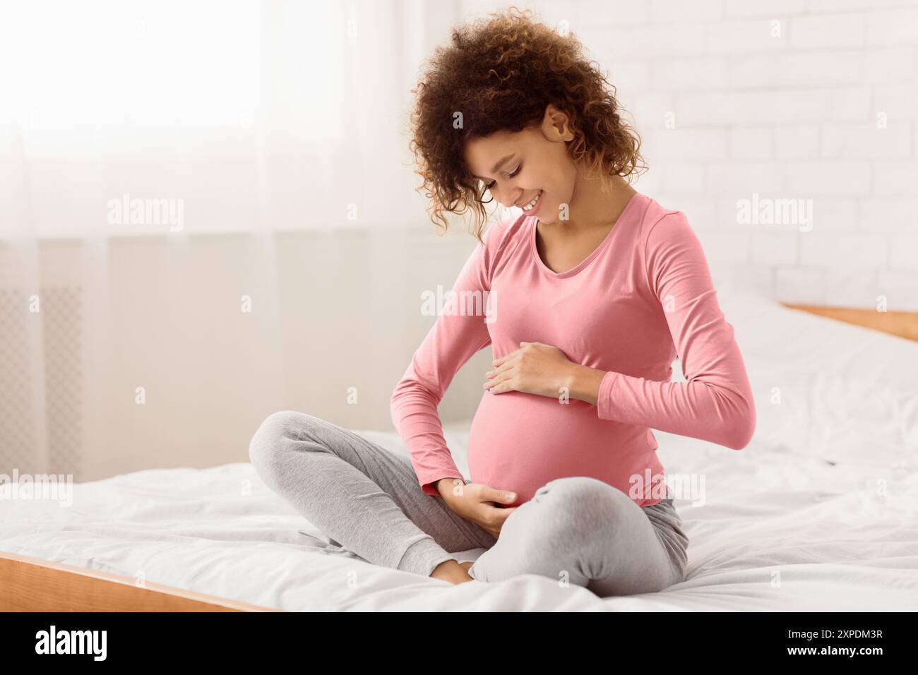 Pretty pregnant woman caressing her belly, talking to her baby Stock ...