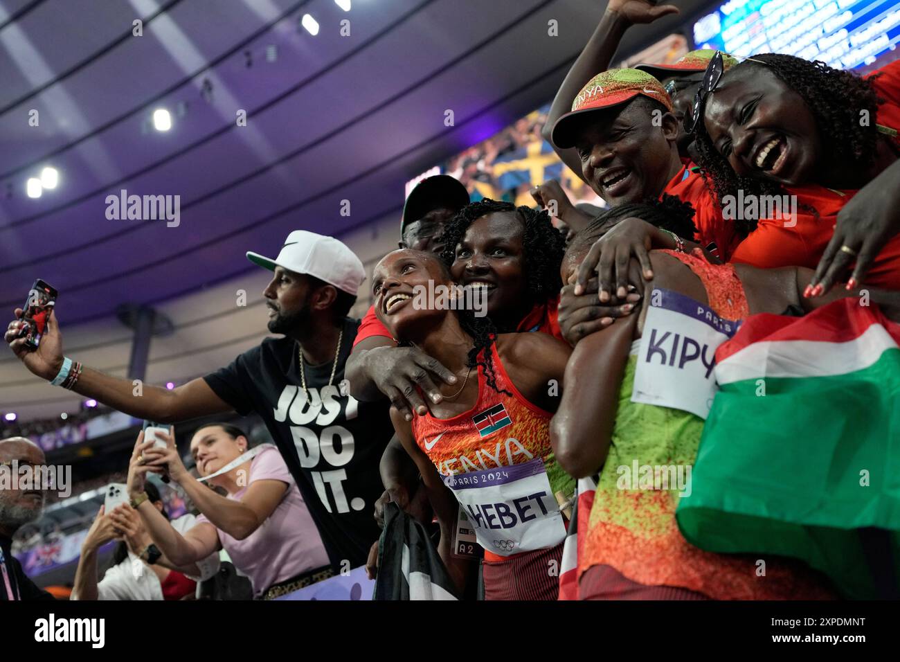 Beatrice Chebet, of Kenya, celebrates with fans after winning the gold ...