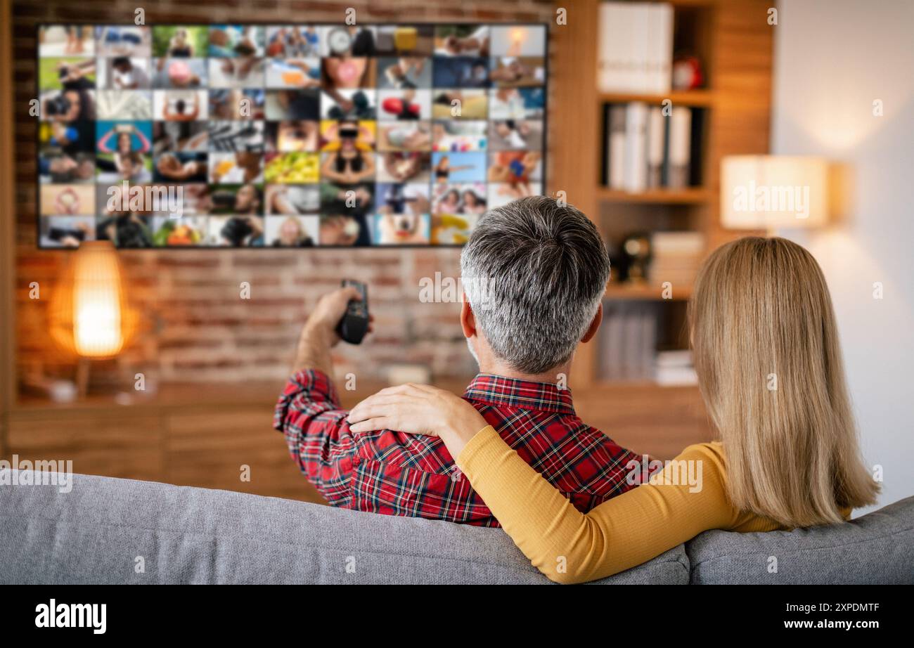 Couple Relaxing on Couch Watching TV With Remote Control Stock Photo ...
