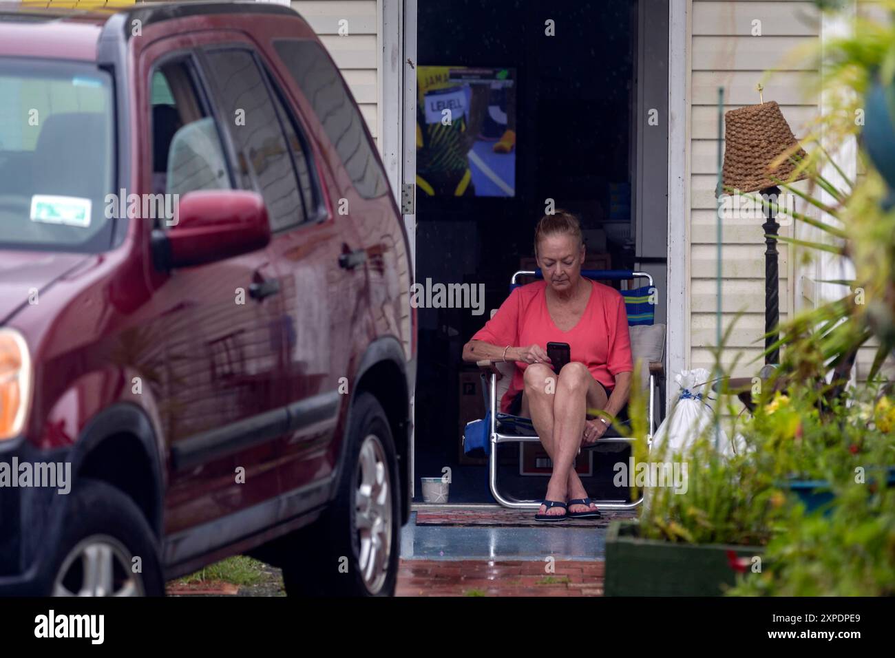 Long-time Tybee resident Angela Thompson looks at her phone while ...