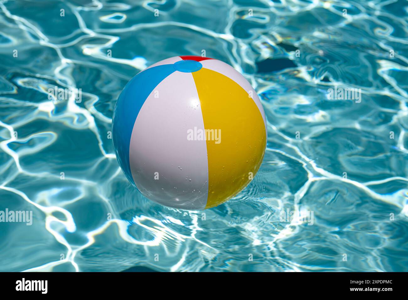 Beach ball. Colorful inflatable ball floating in swimming pool. Summer ...