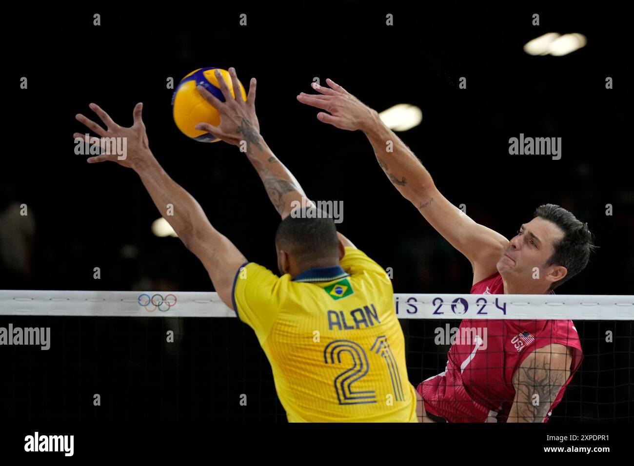 Matthew Anderson, right, of the United States, spikes the ball during a ...