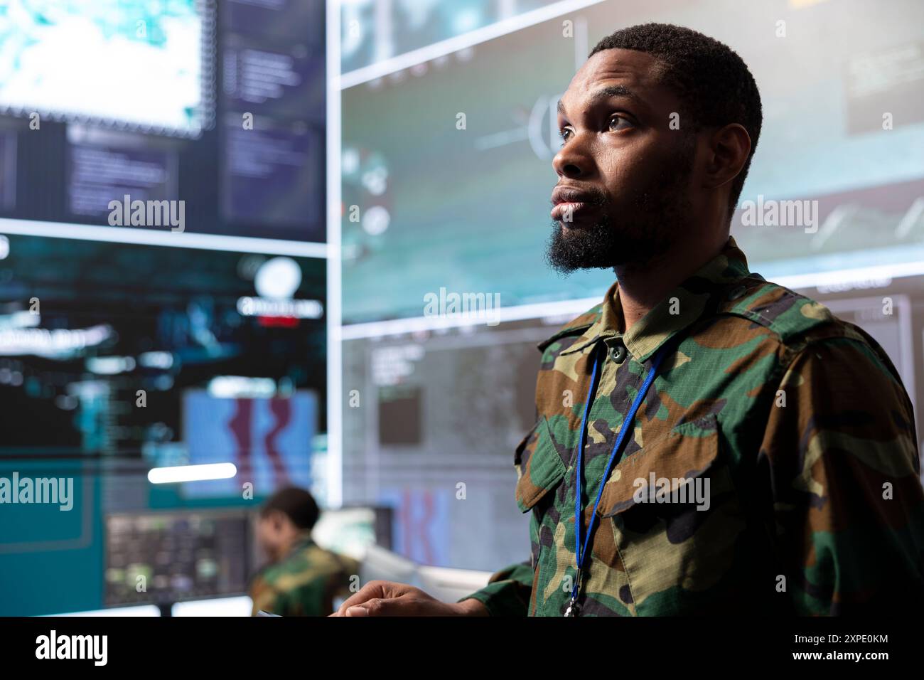 Army professional in uniform works in a mission control center ...