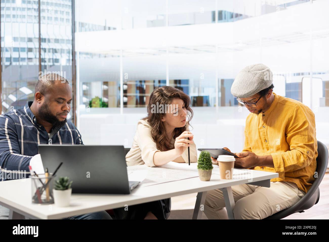 Corporate clients and their real estate agent examining blueprints and ...