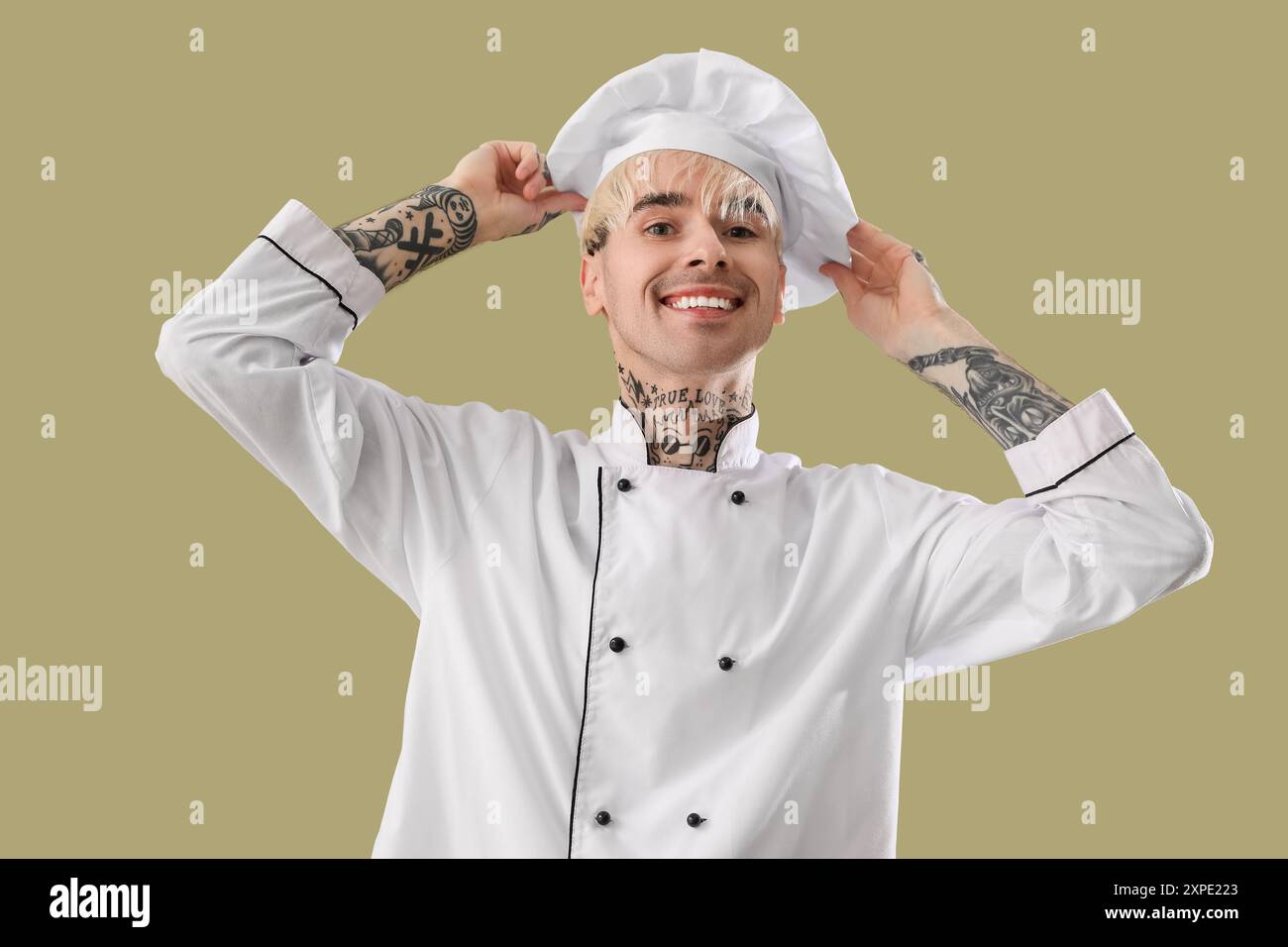 Tattooed male chef on green background Stock Photo - Alamy