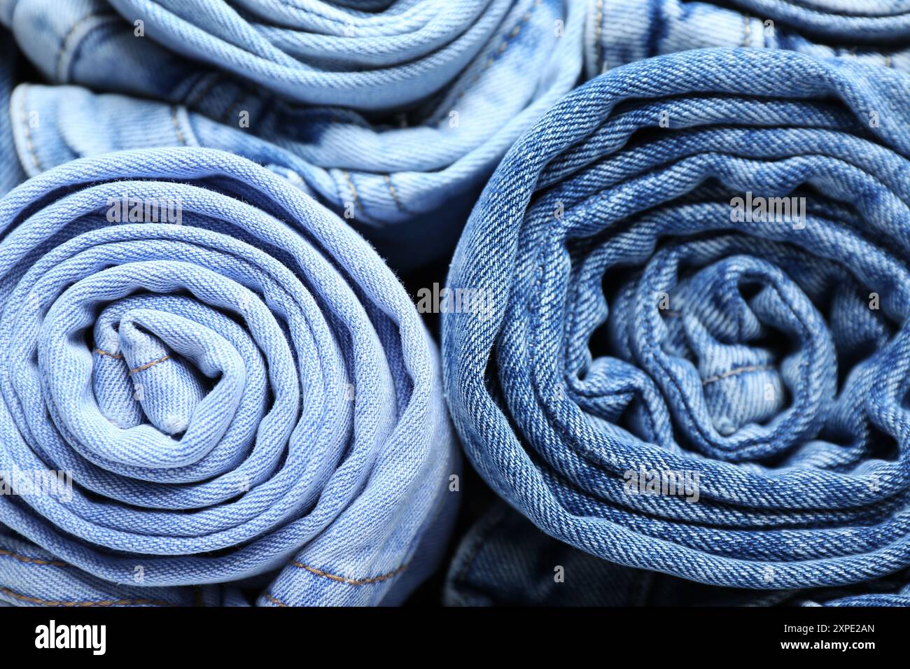 Rolled jeans as background, closeup Stock Photo - Alamy