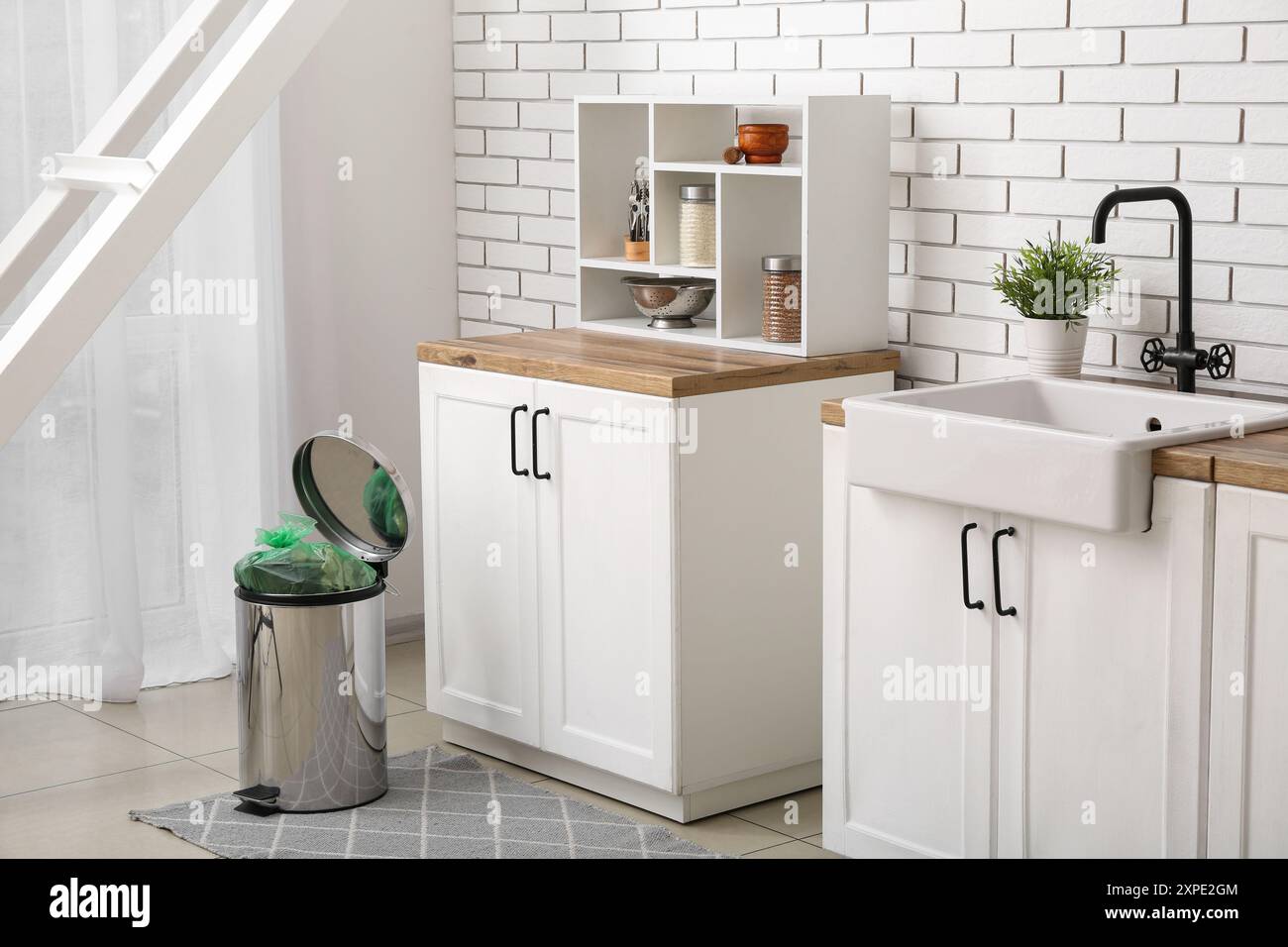Full trash bin in interior of modern kitchen Stock Photo - Alamy