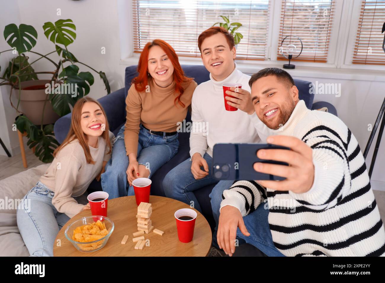Group of young friends with beer playing jenga game at home Stock Photo ...