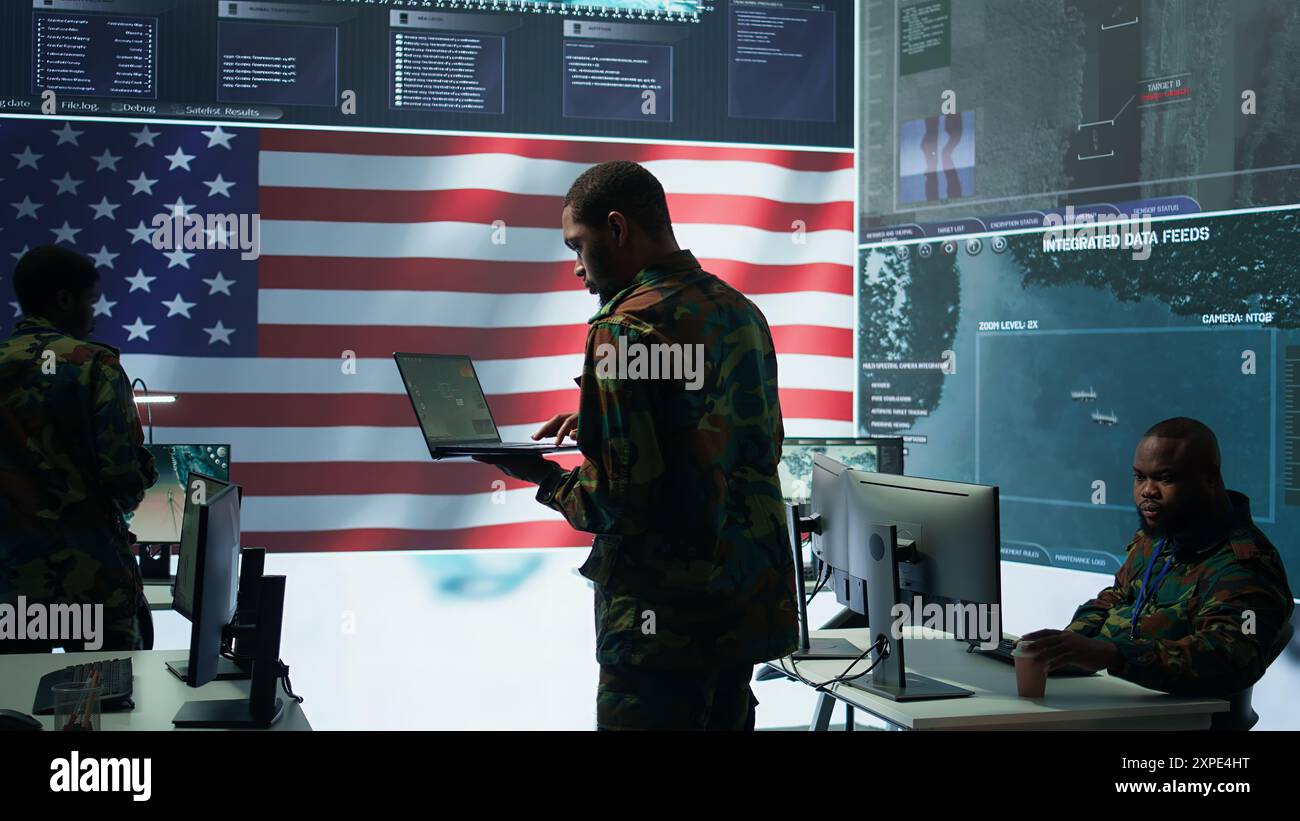 Professionals in US military uniforms operate computers and big screen ...