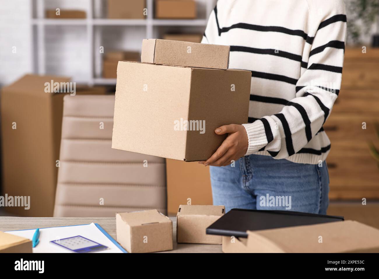 Young woman putting parcel boxes on table in warehouse, closeup Stock ...