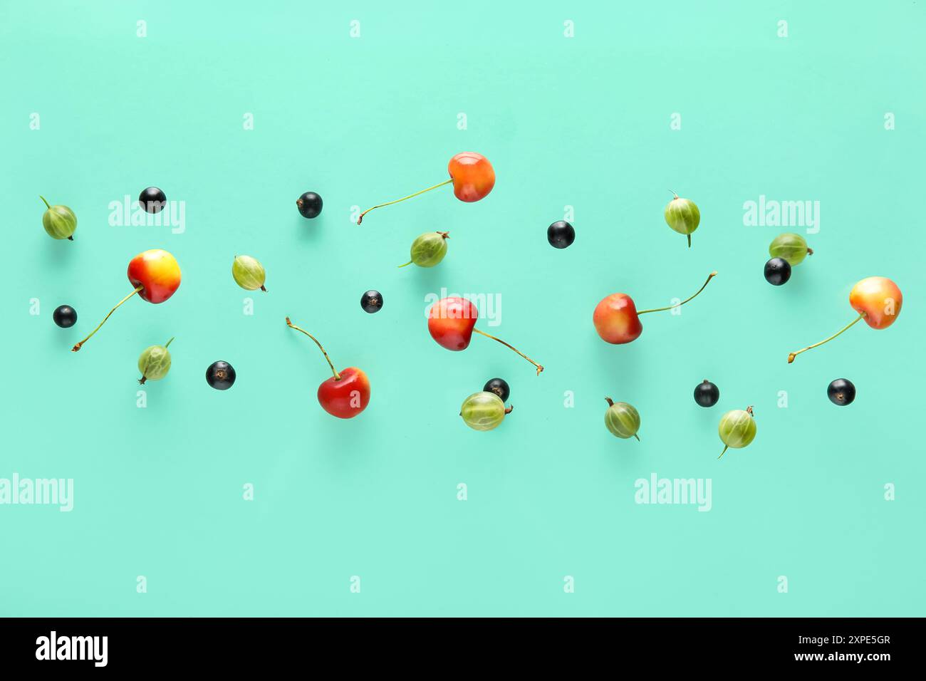 Different berries flying on turquoise background Stock Photo - Alamy