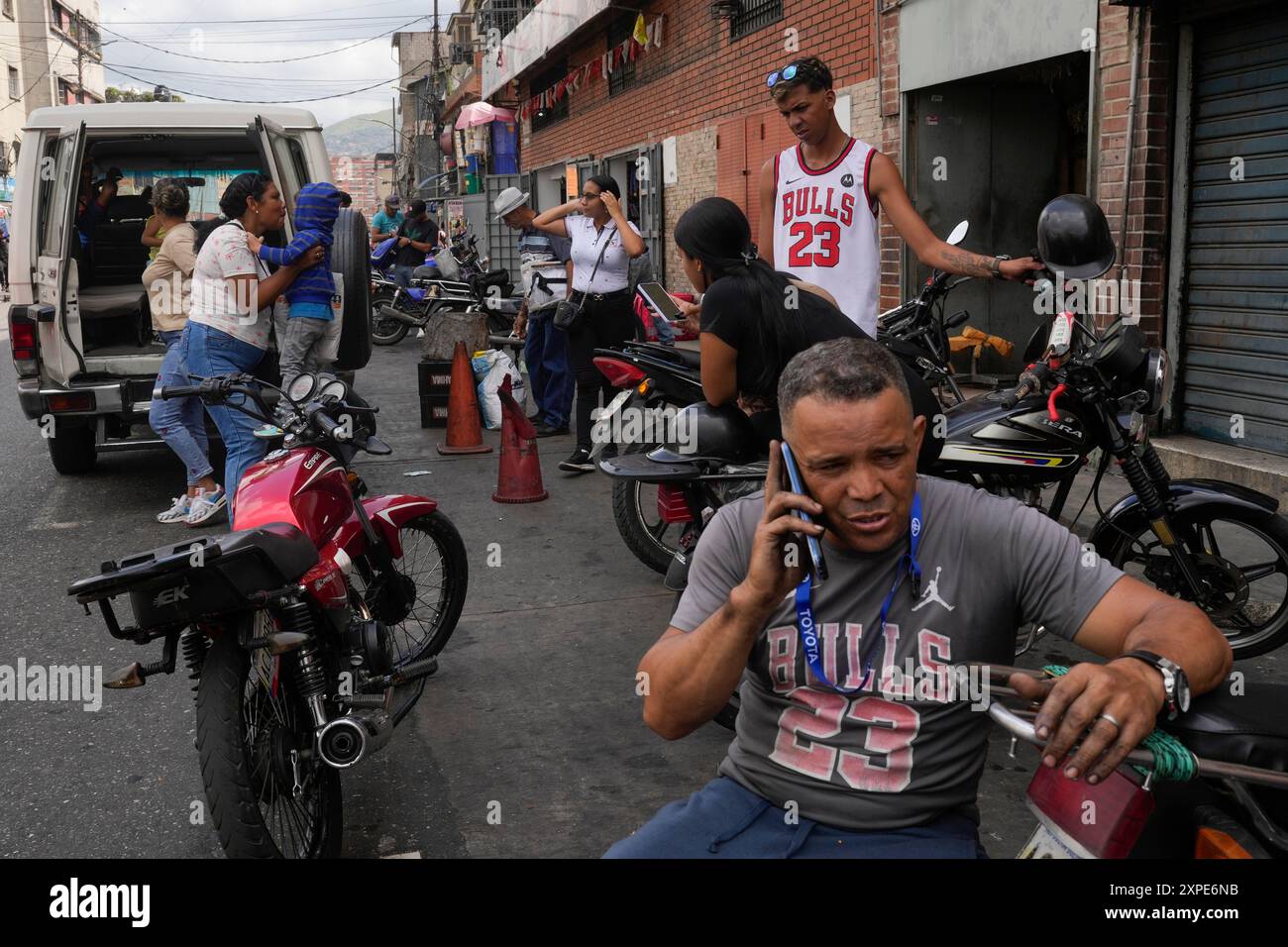 People hang out on a street of Catia neighborhood in Caracas, Venezuela ...