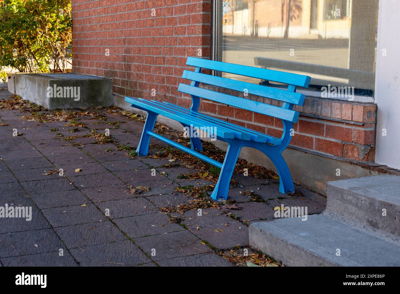Blue bench near the window of a shop in the town Stock Photo - Alamy