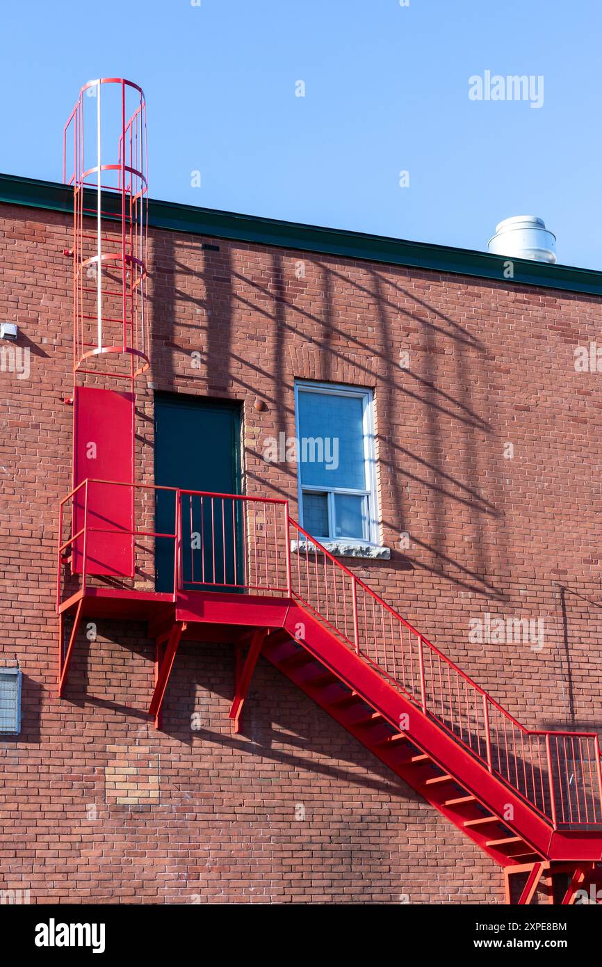 Red metal stairs outside the building, fire escape Stock Photo - Alamy