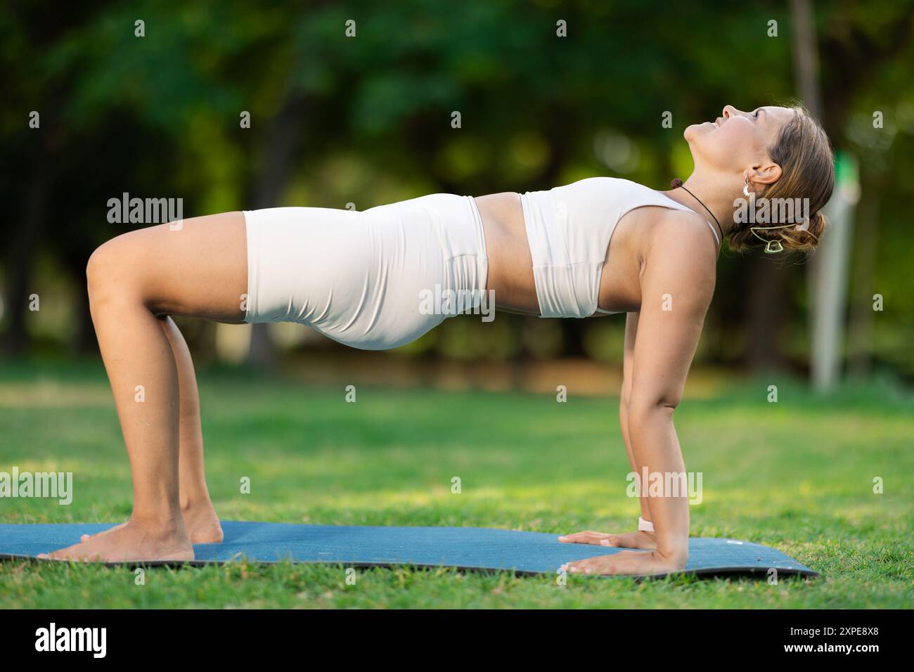 Girl performing Reverse Table Top Pose in summer park Stock Photo - Alamy