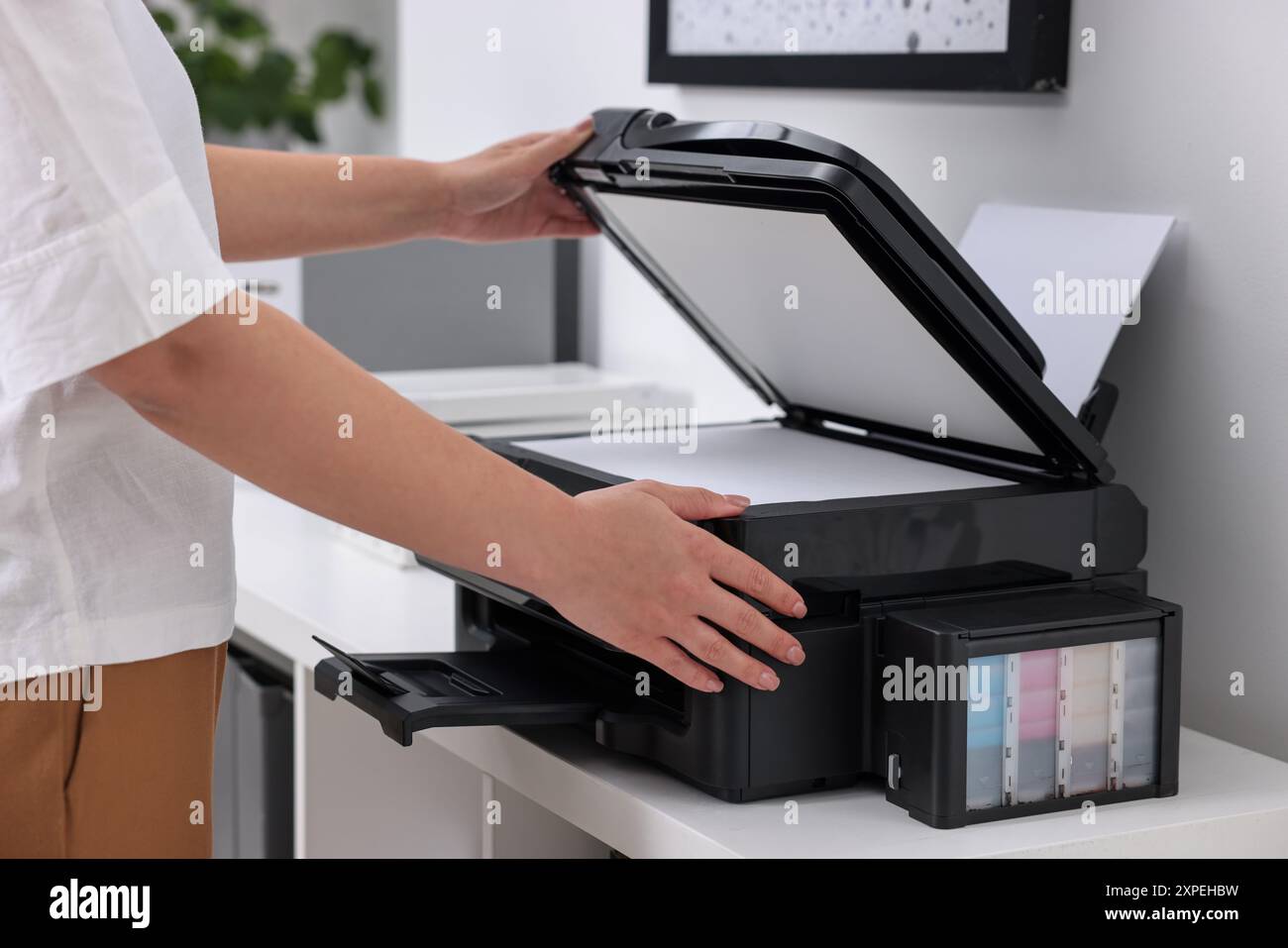 Woman using modern printer at workplace indoors, closeup Stock Photo ...