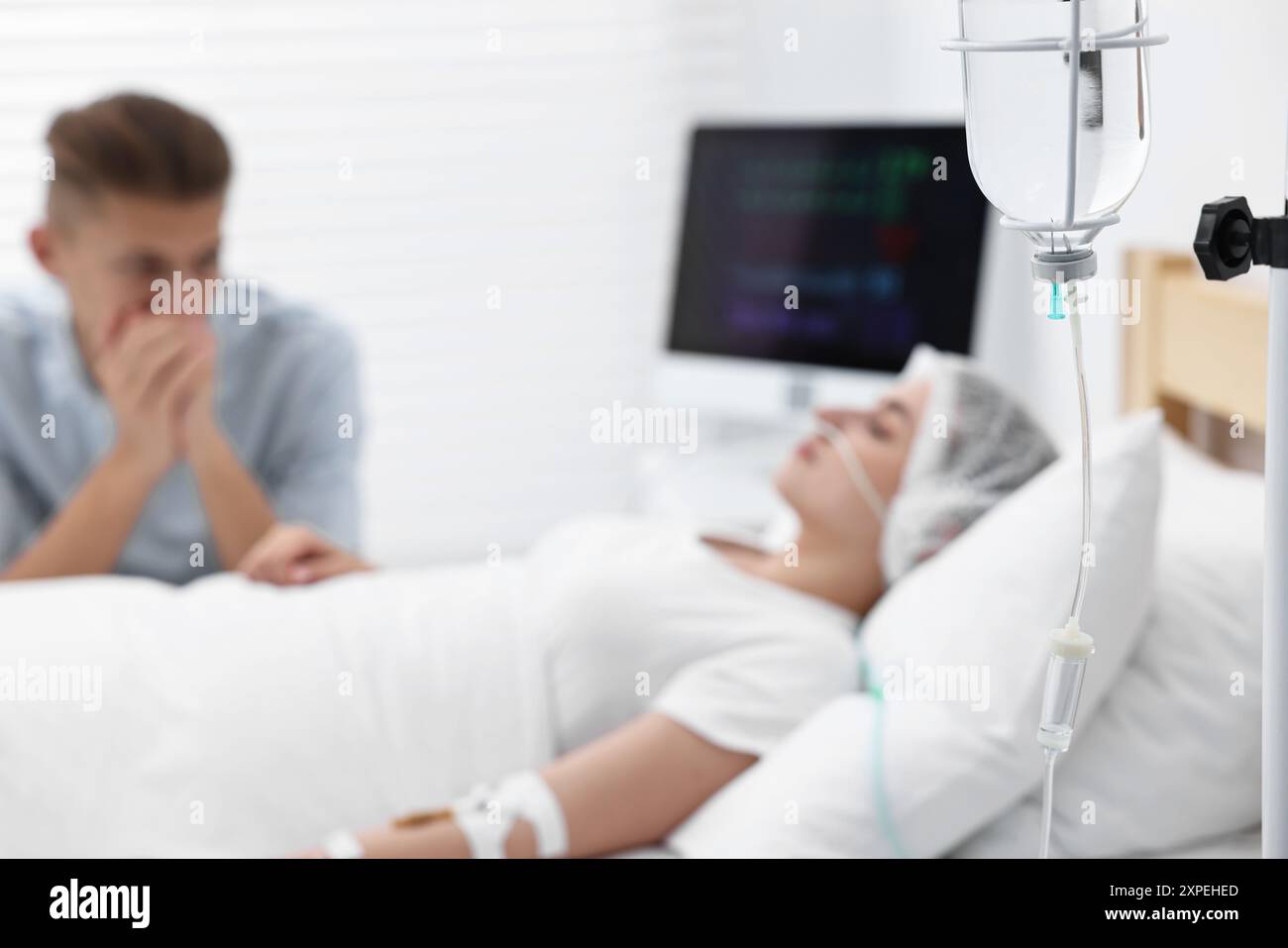Coma patient. Sad young man near his unconscious wife in hospital ...