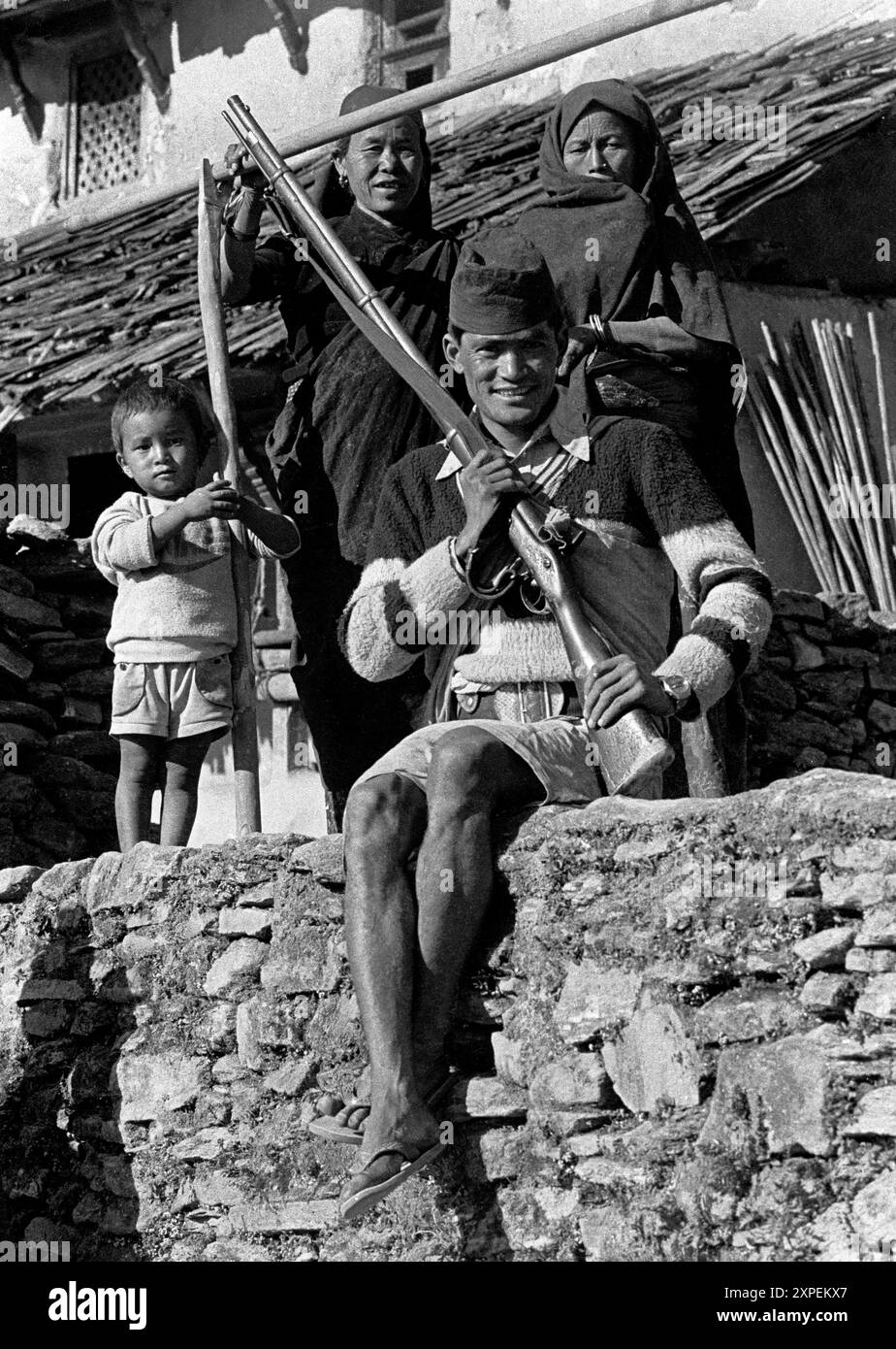 A Nepali man with an old rifle and his family in the middle hills ...