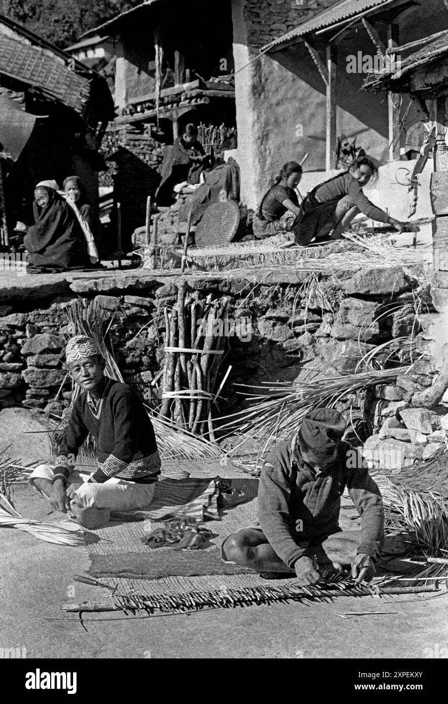 Nepali men and women weaves matts by hand in the middle hills village ...
