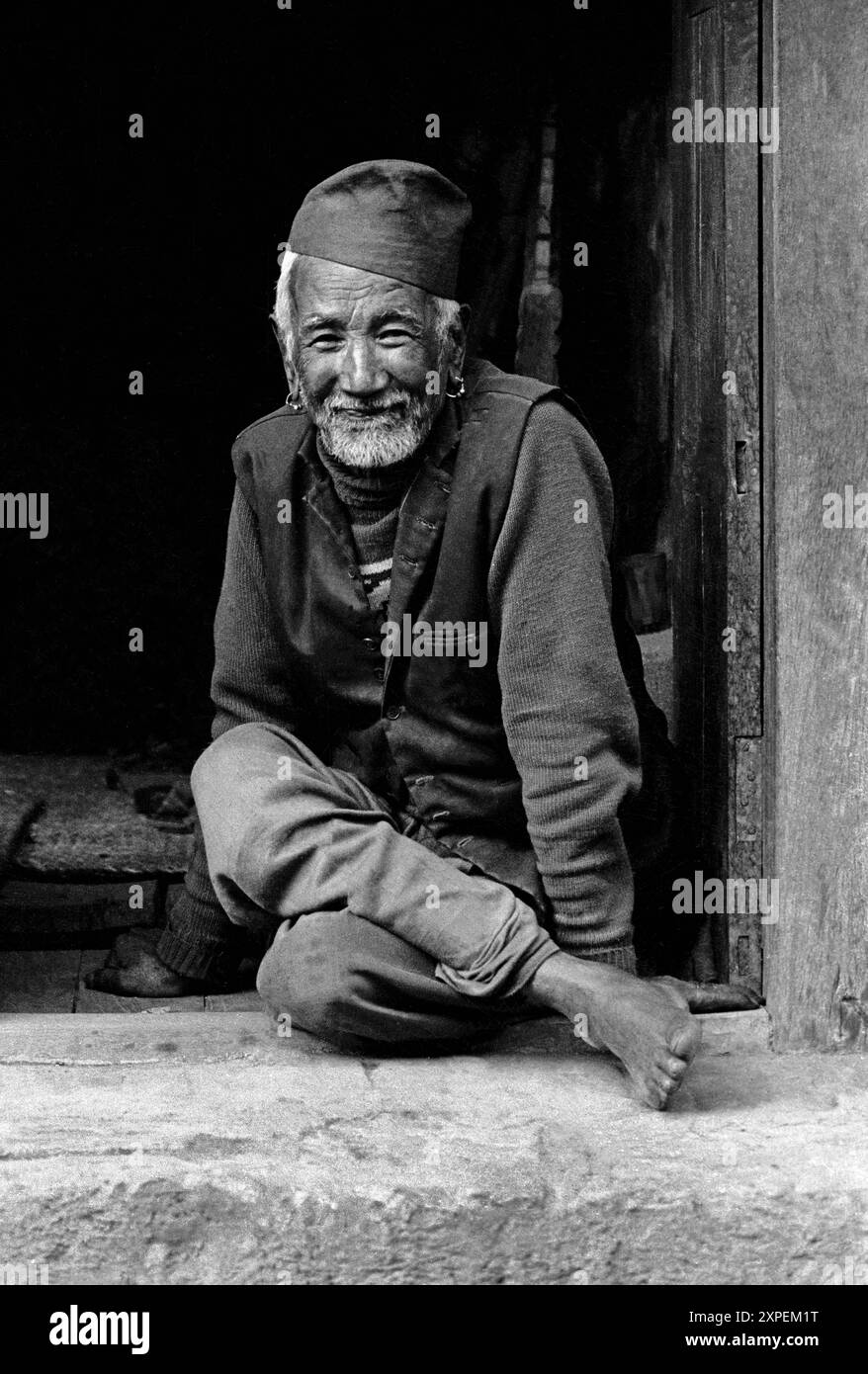 A Nepali man wearing tradiional clothing including a topi hat ...