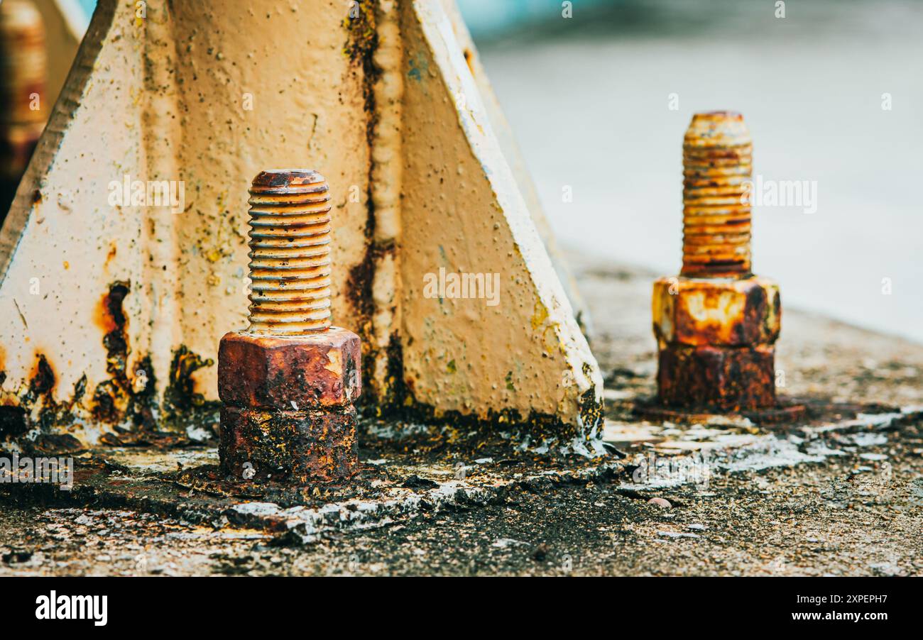 Rusty bolts holding a metal construction are showing corrosion, a ...
