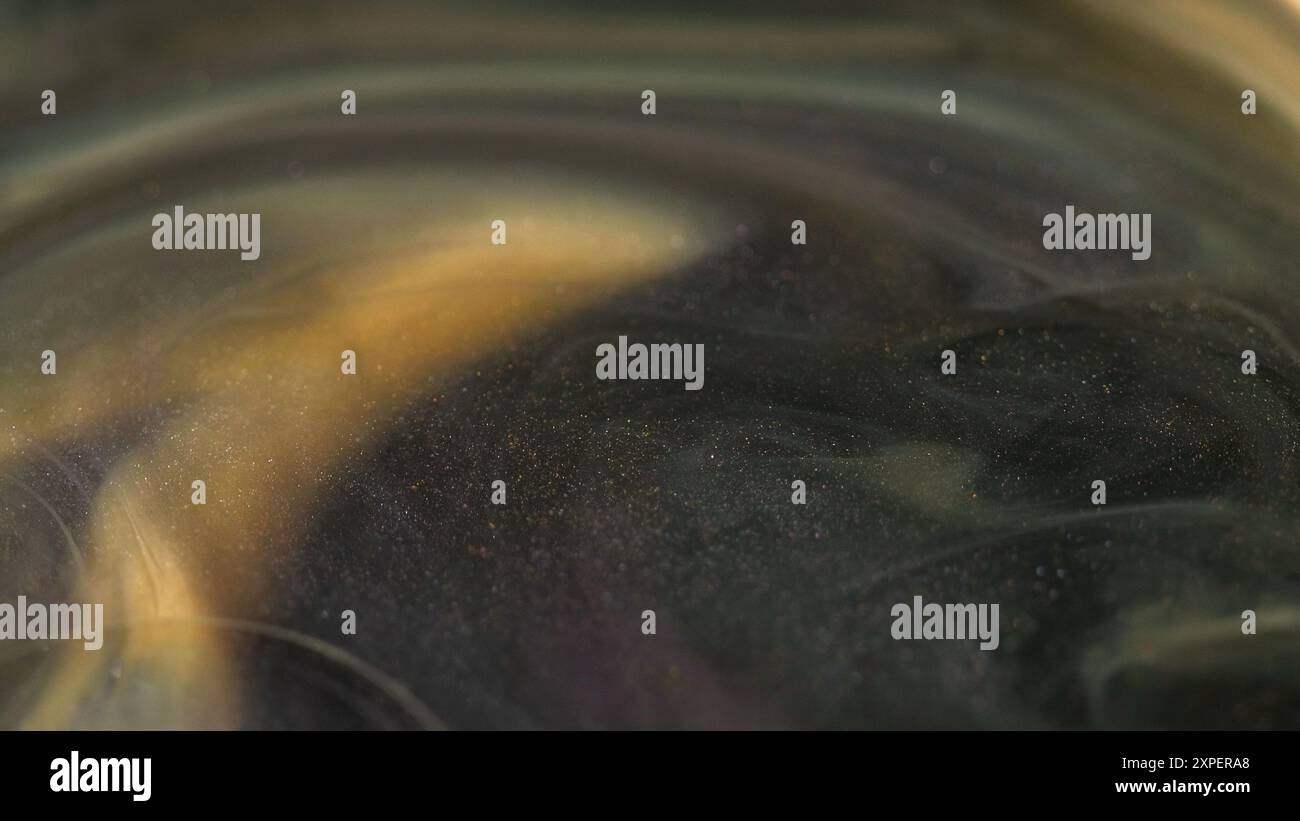 Luxury ink. Shimmer paint. Defocused black golden color floating ...