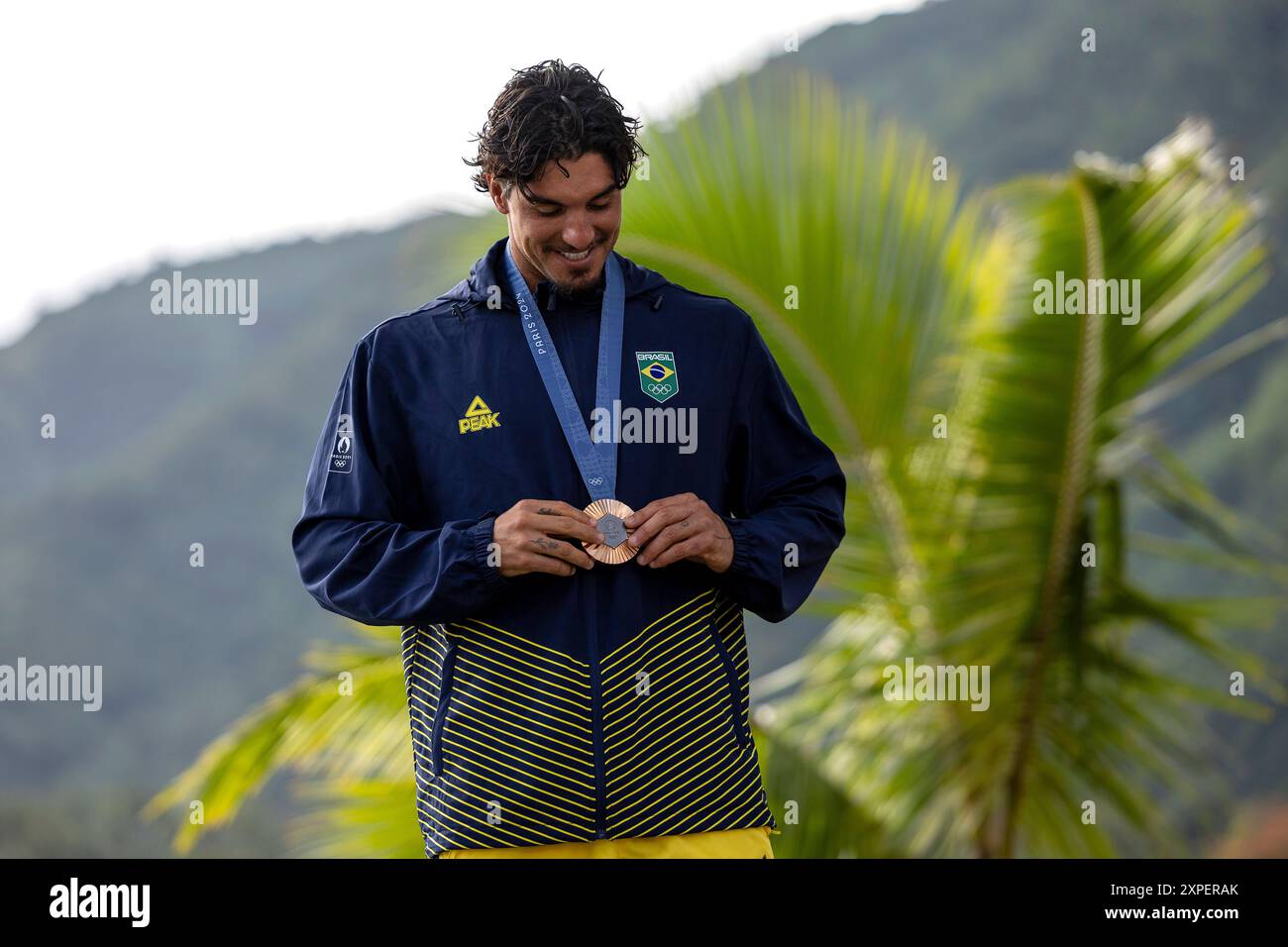 Bronze medalist Gabriel Medina of Brazil looks at his medal on the ...