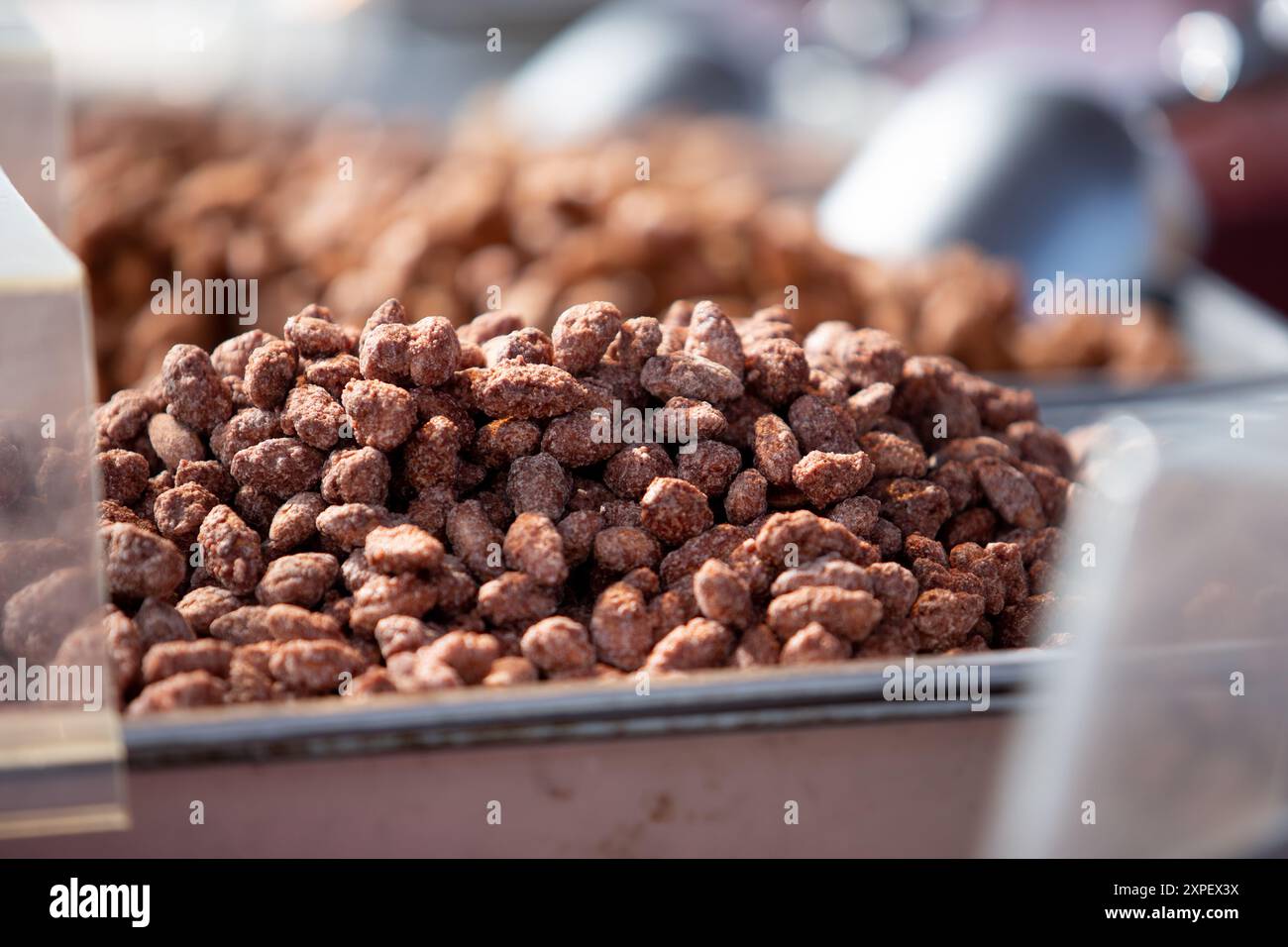 A view of several trays of roasted assorted nuts, on display at a food ...