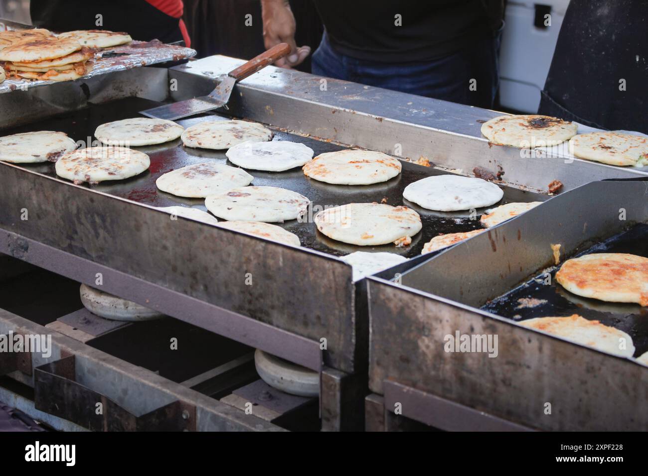 A view of several pupusas cooking on a griddle Stock Photo - Alamy