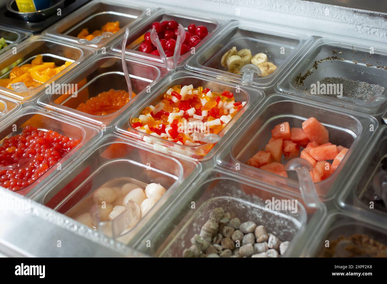 A view of several containers full of toppings in a frozen yogurt or ice ...