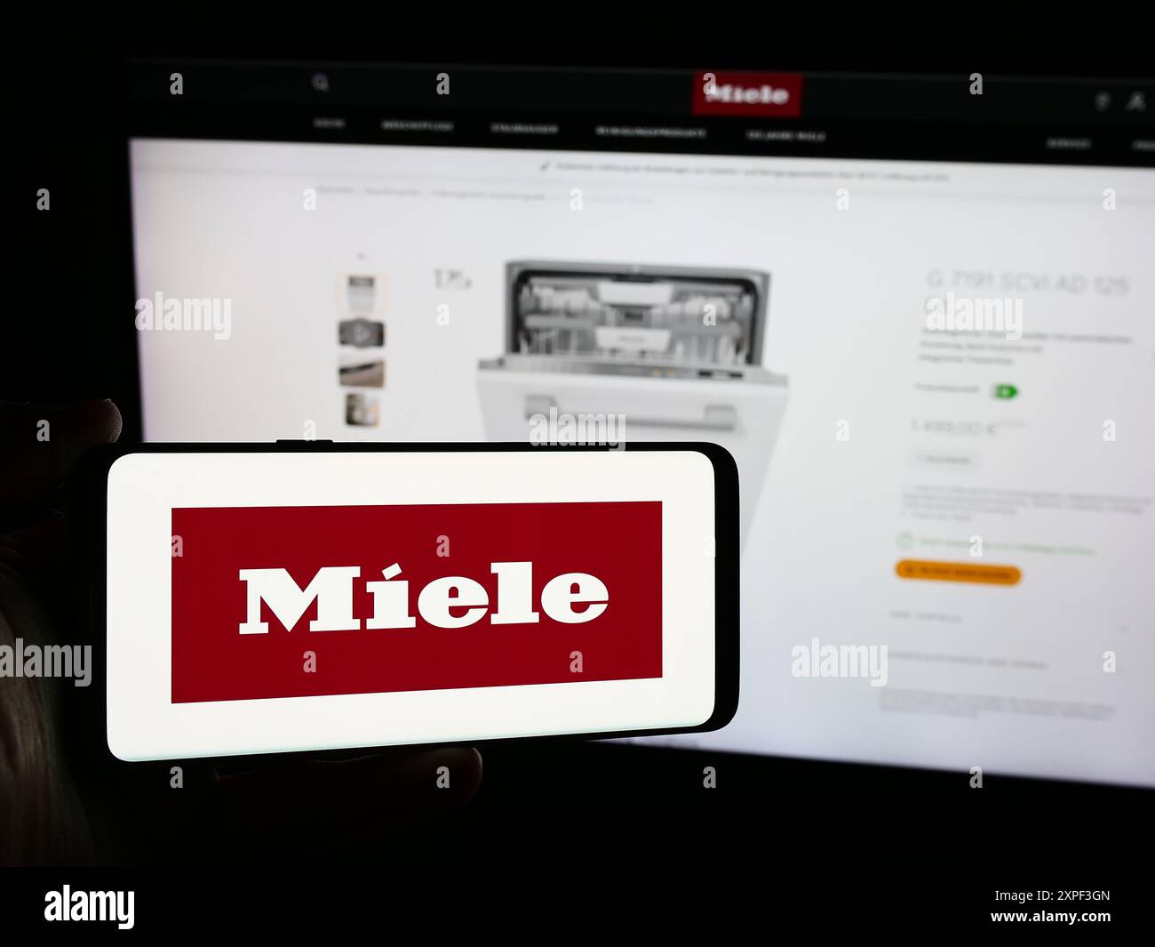 Person holding smartphone with logo of German household appliances ...