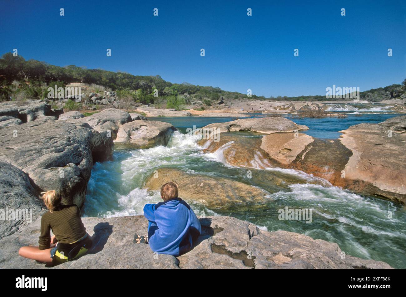 Children looking at rapids at channel of Pedernales River, Pedernales ...