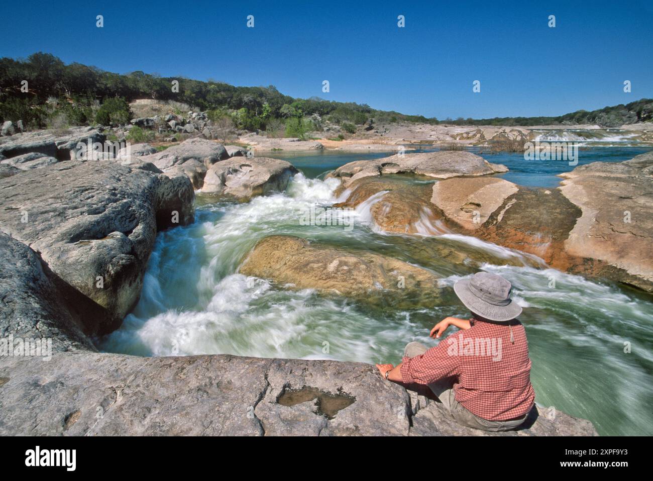 Visitor looking at rapids at channel of Pedernales River, Pedernales ...