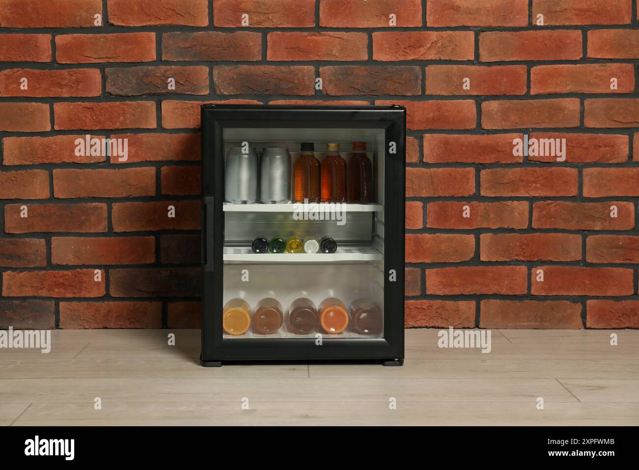 Mini refrigerator with drinks near brick wall Stock Photo - Alamy