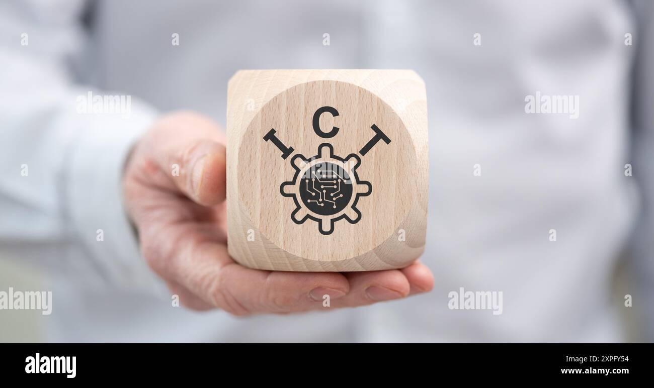 Hand holding a wooden cube with symbol of ict concept Stock Photo - Alamy