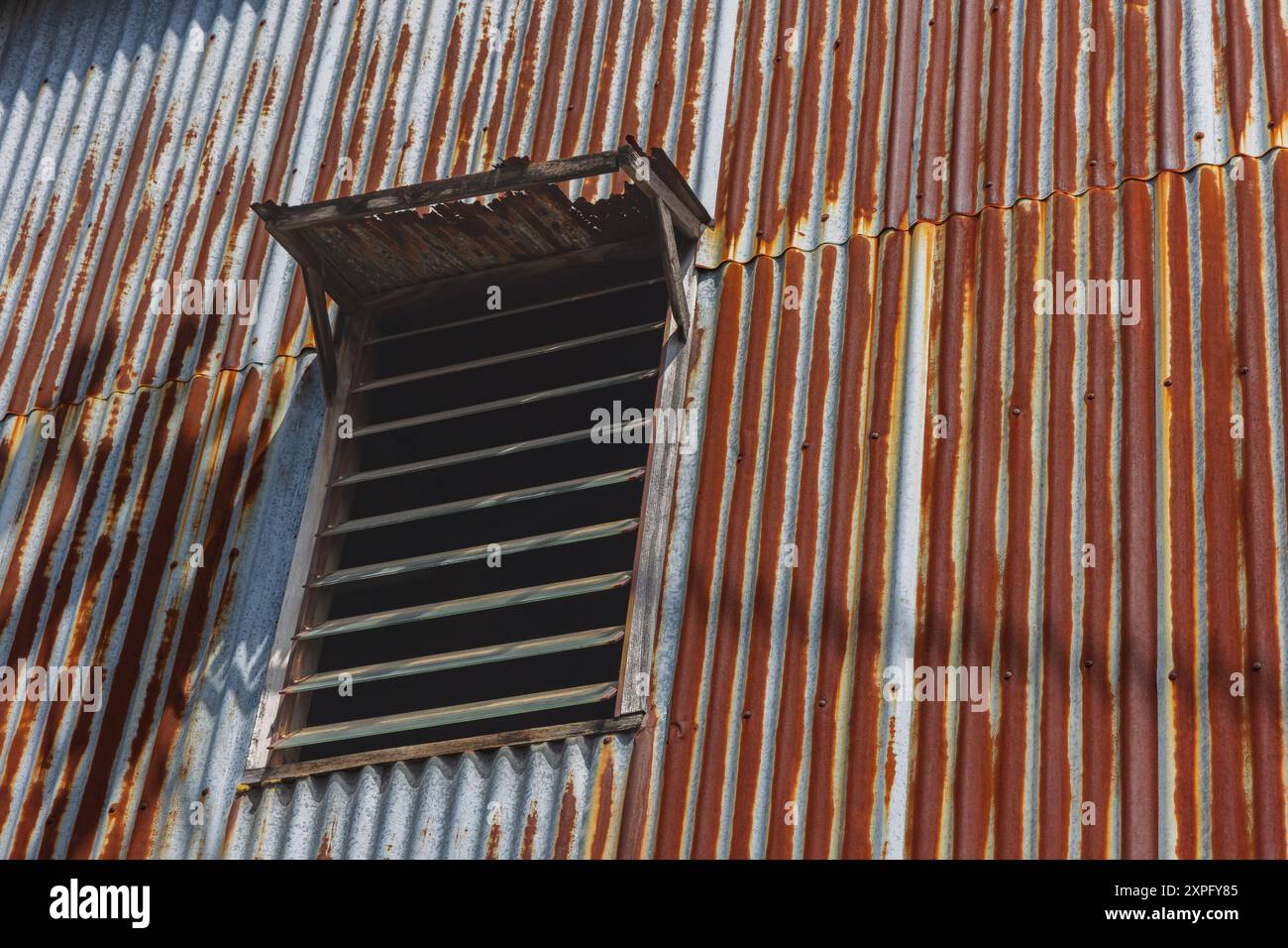 Metal sheet house with windows rusted and damaged. Exterior of a residential house rusted and ...