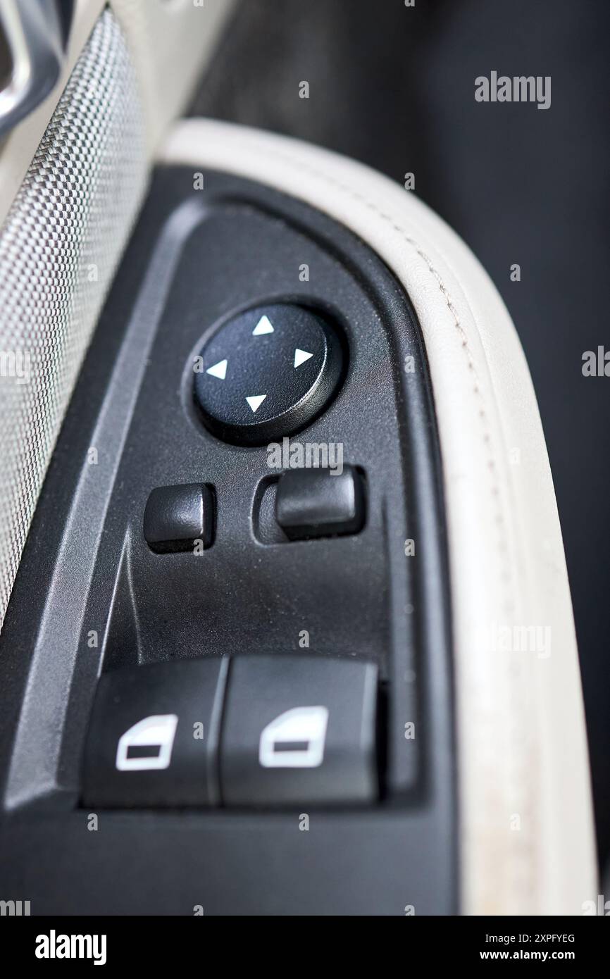 Modern hybrid electric car closeup interior detail. Driver door control ...