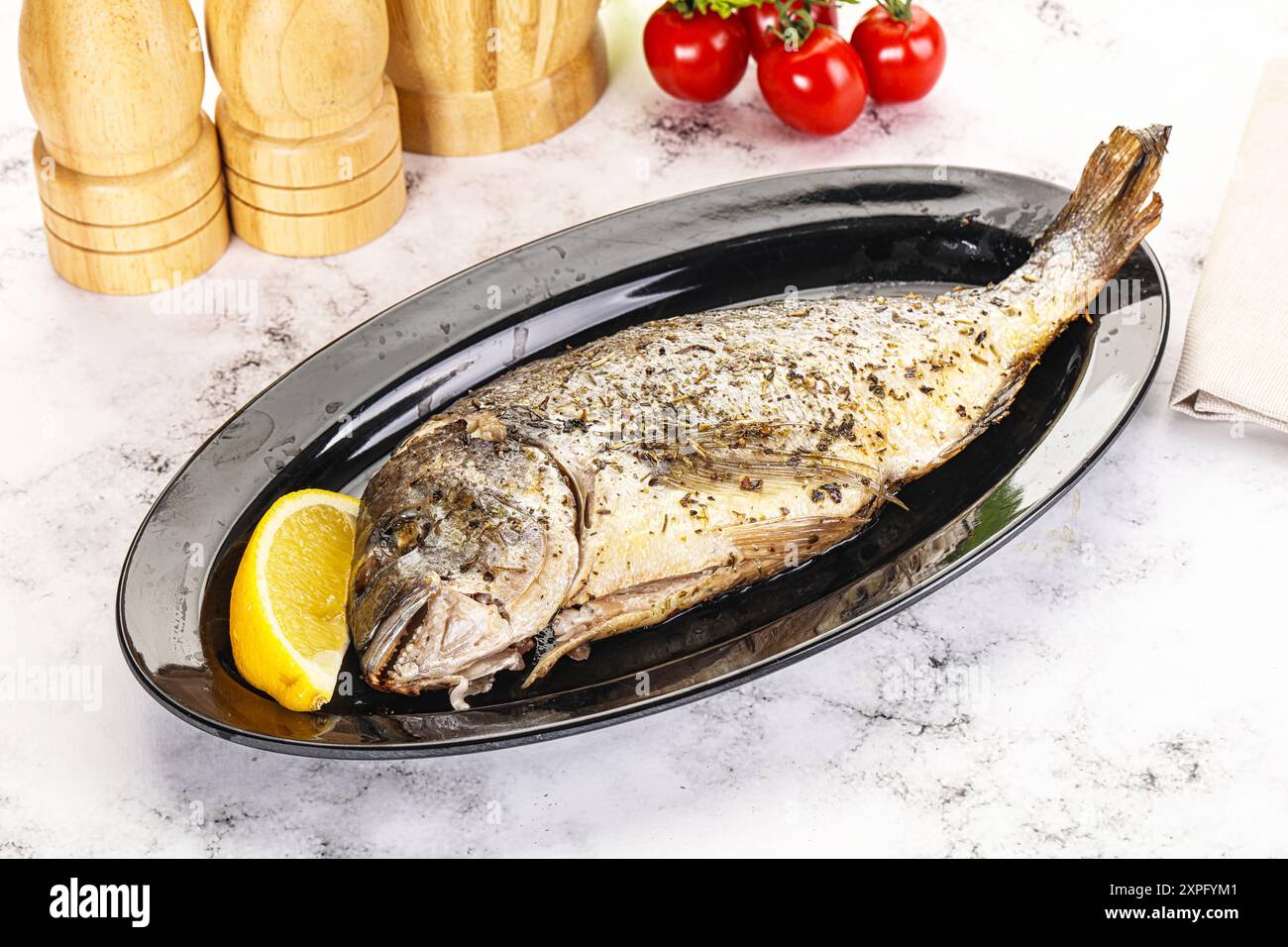 Baked Dorado fish served lemon slice Stock Photo - Alamy