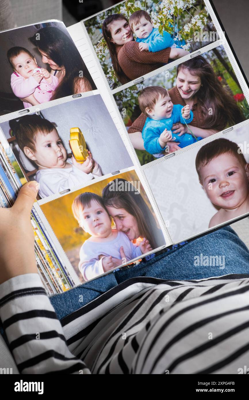 Woman looking at family photo album about her family Stock Photo - Alamy