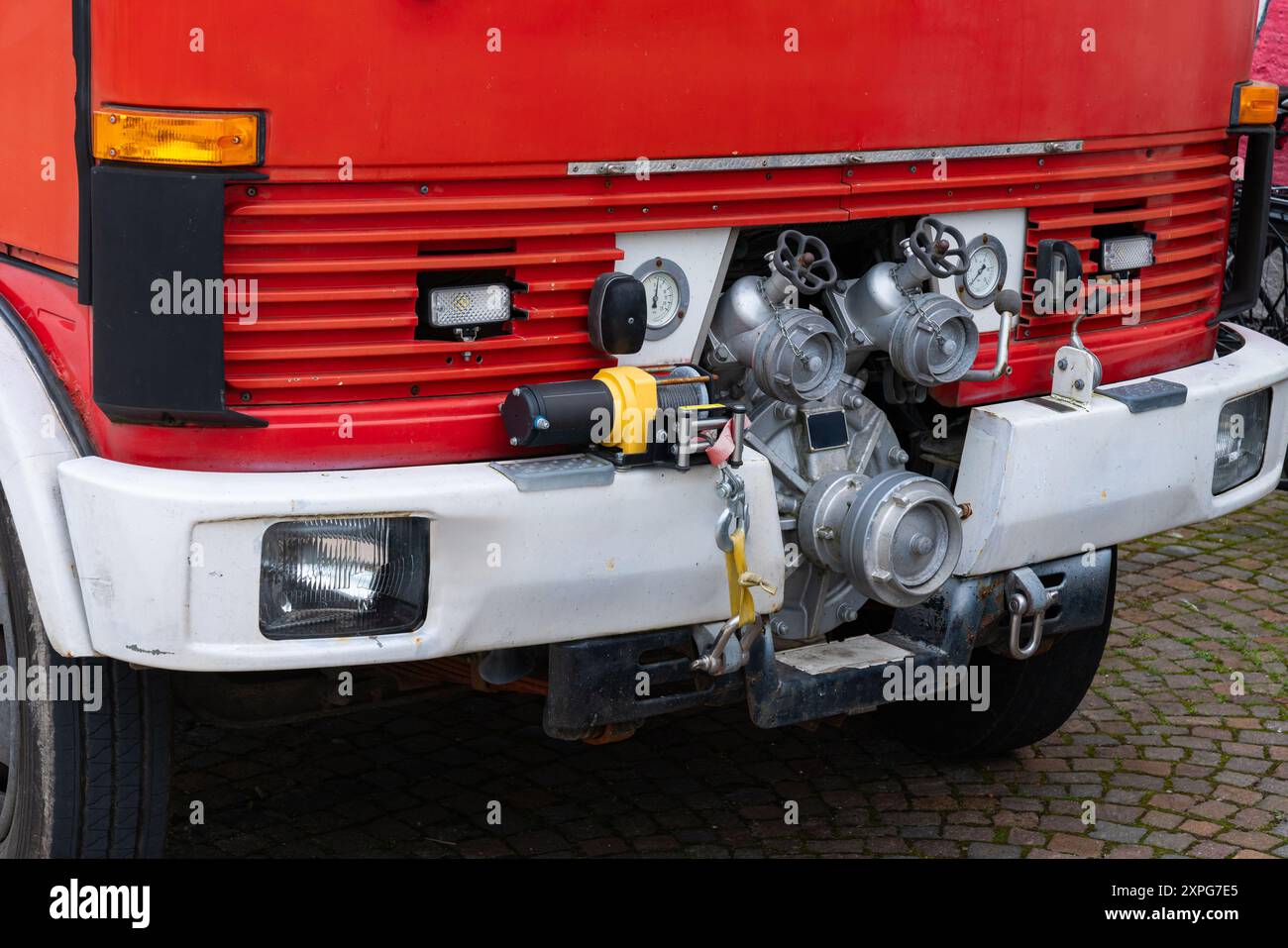 The front of a red fire truck showcases its engine components ...