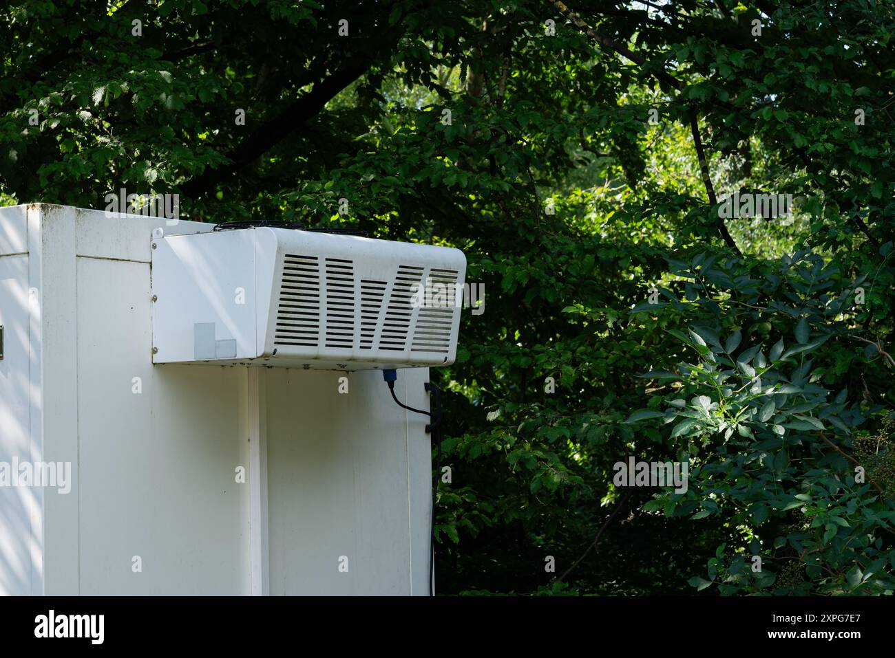 An air conditioning unit is installed on the exterior wall adjacent to ...