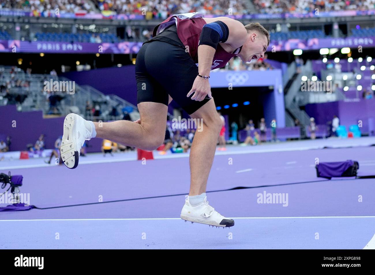 Patriks Gailums, of Latvia, yells as he grabs his leg while competing ...