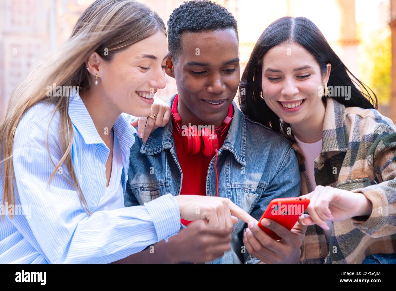Three students having fun with mobile phones creating content on social ...
