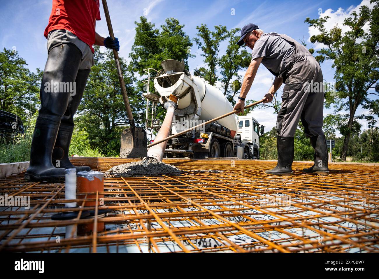 Worker Distributing Concrete Pouring from a Mixer Truck onto Rebar ...