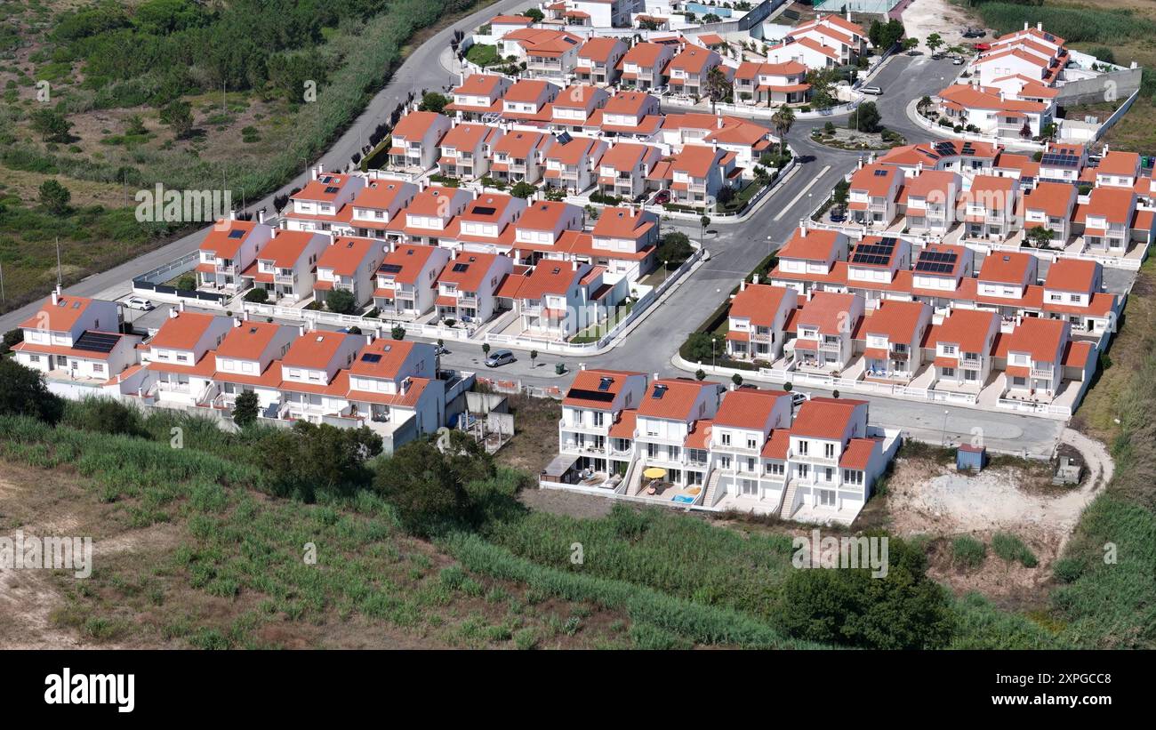 A sprawling residential community features rows of houses, each with ...