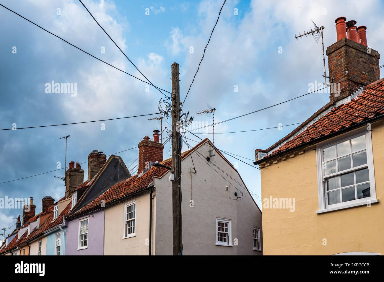 Telephone wires running to cottage roofs in Southwold, Suffolk, UK. Old ...