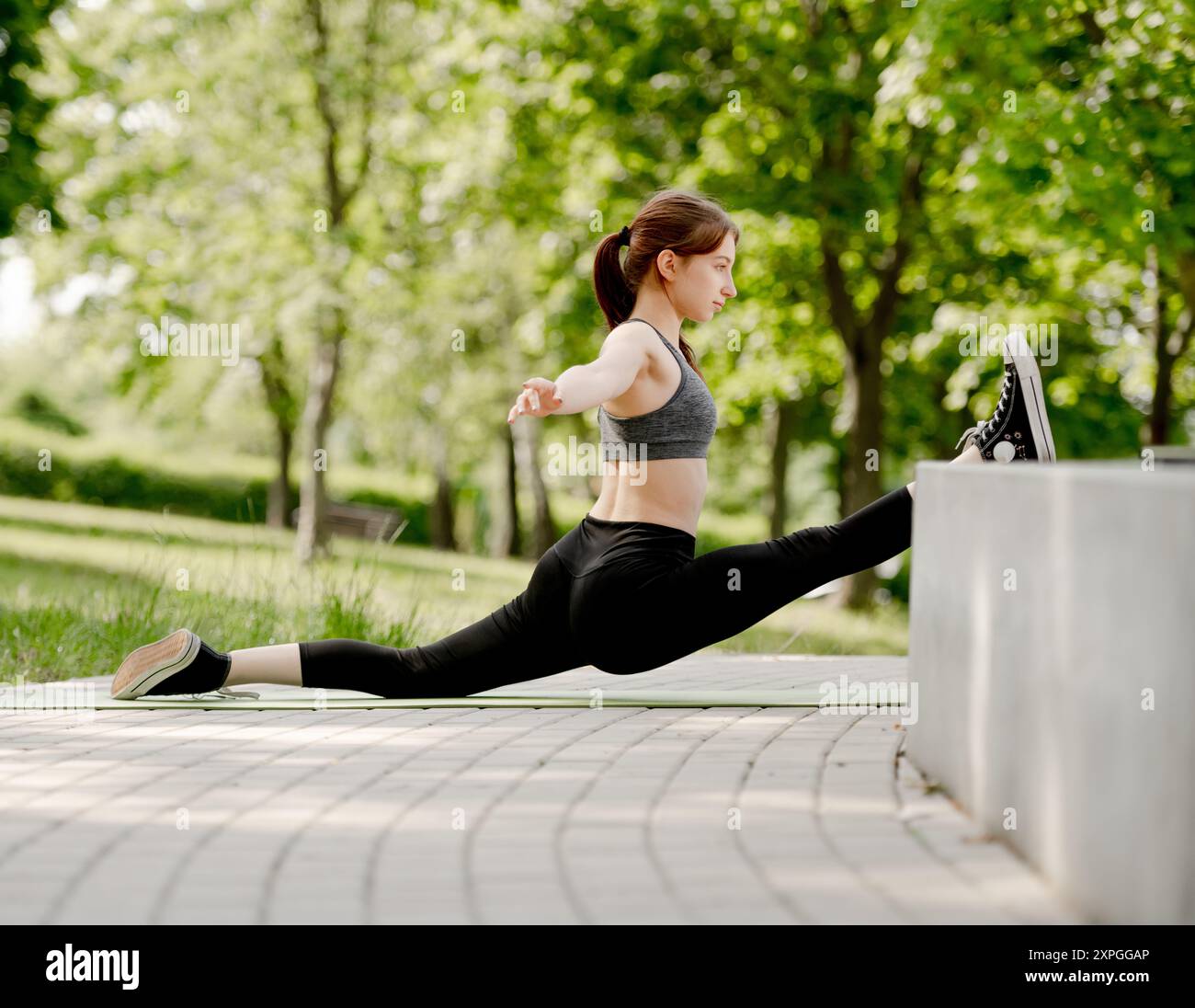 Girl Dancer Sits In Splits At Park For Warm-Up, View From Behind Stock ...